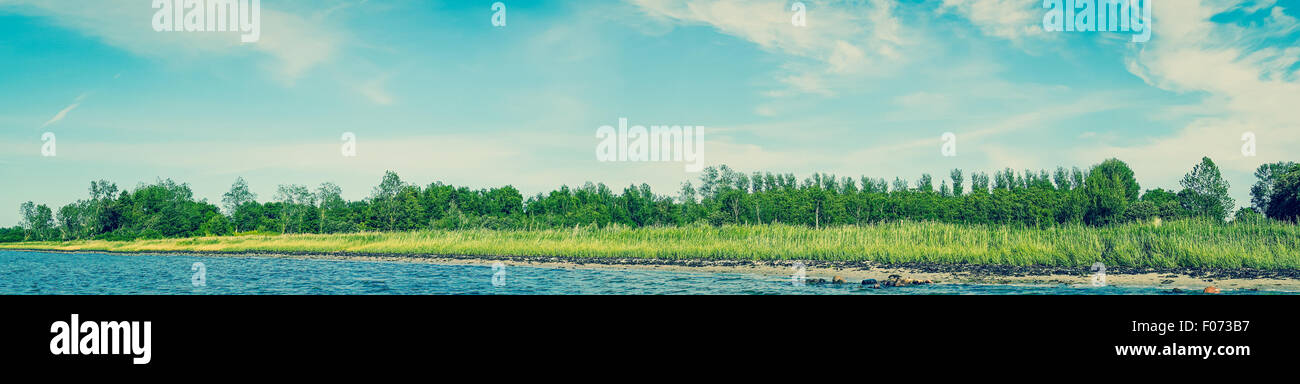 Panorama landscape of a Scandinavian beach with green trees and blue ...