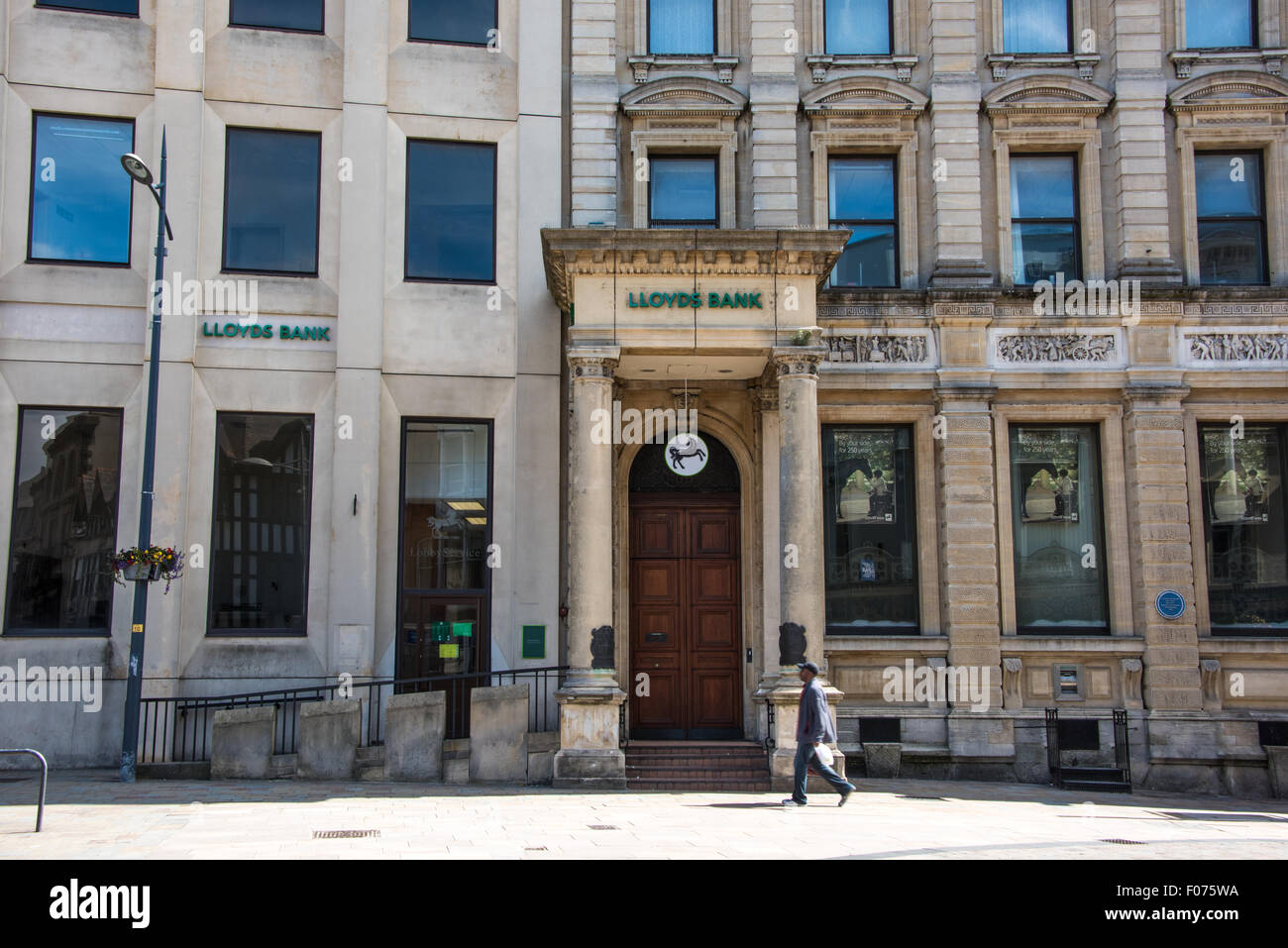 A Man walking past The Lloyds Bank on high street Wolverhampton West ...