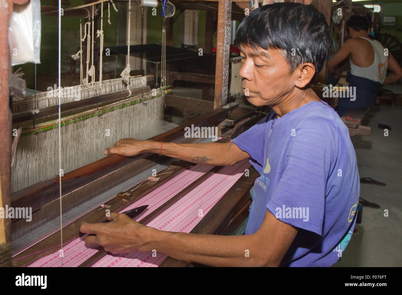 ASIA, MYANMAR (BURMA), Mandalay, man weaving with loom and sliders ...