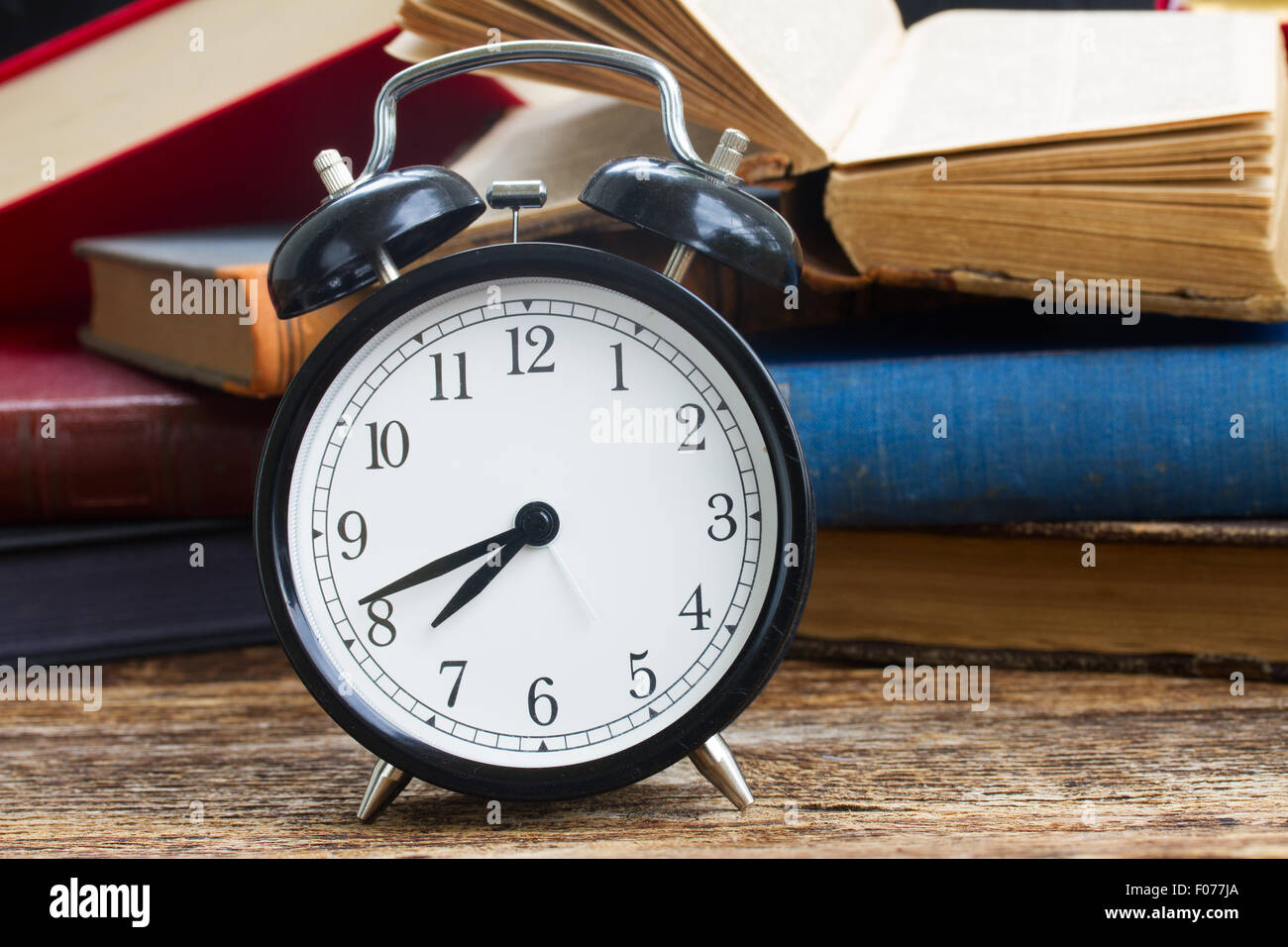 pile of books with clock Stock Photo - Alamy