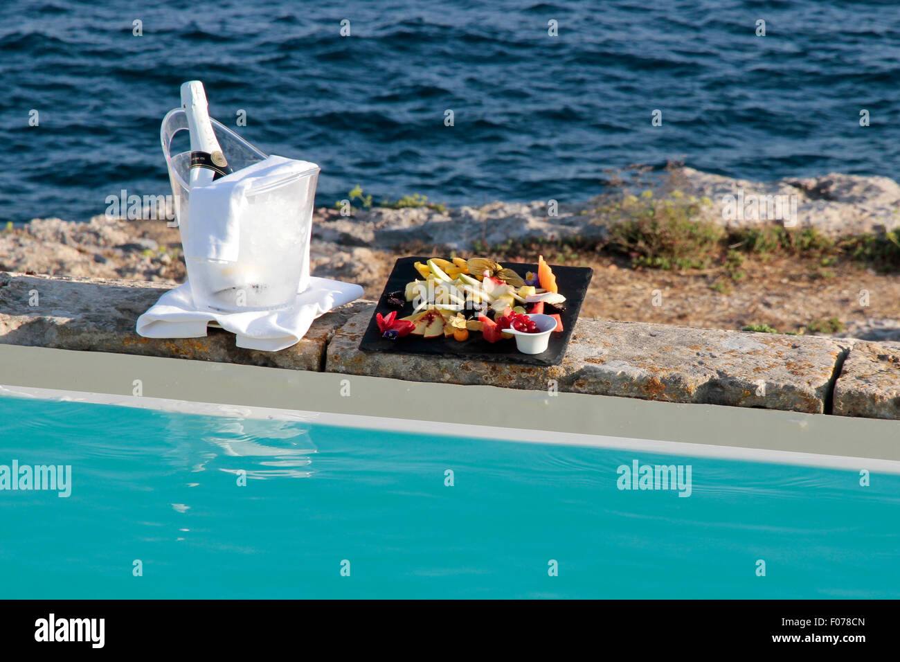 Champagne Moet white bottle and fresh fruits dish by the pool Stock ...