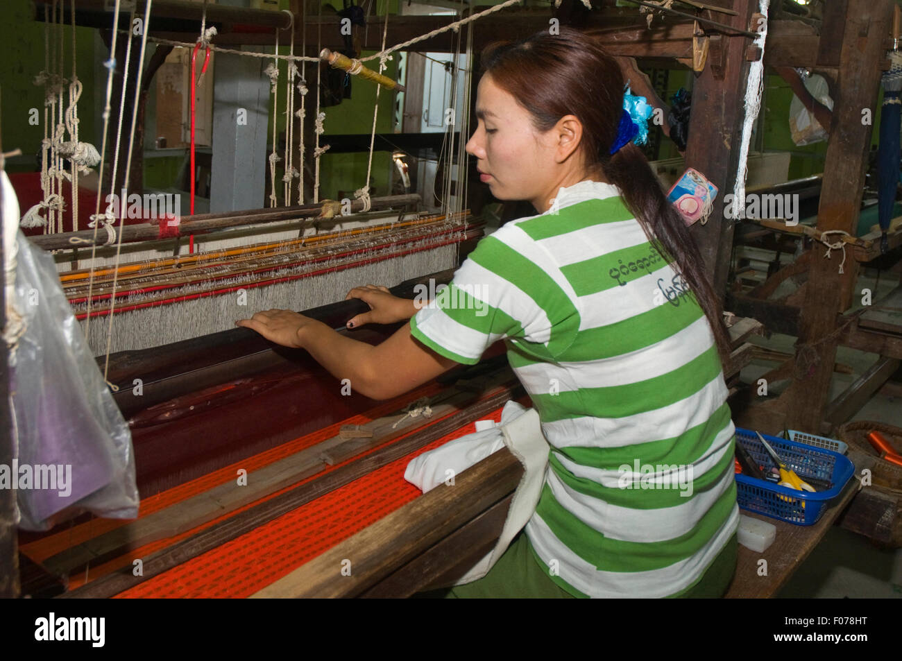 ASIA, MYANMAR (BURMA), Mandalay, woman weaving with loom and sliders ...