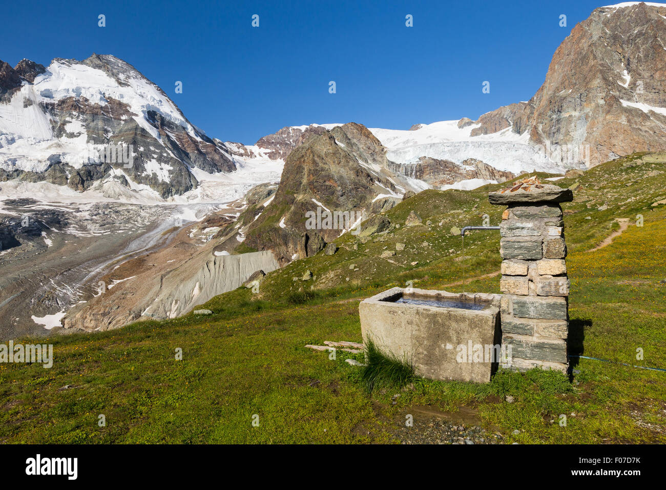 Alpine landscape with fountain. Dent d'Herens mountain, Zmutt valley ...