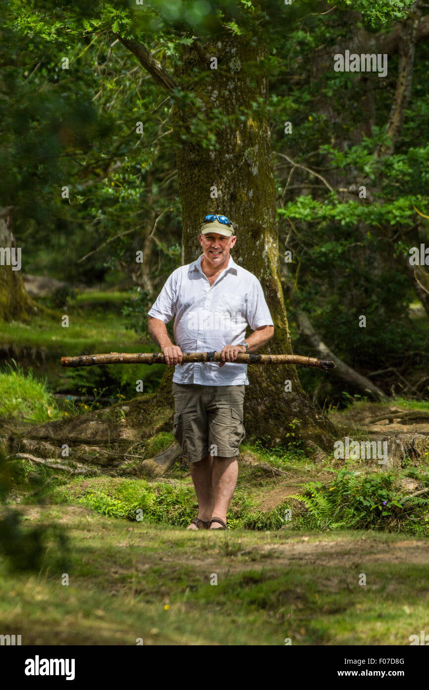 happy playing in forestry finding a large stick as a weapon Stock Photo ...