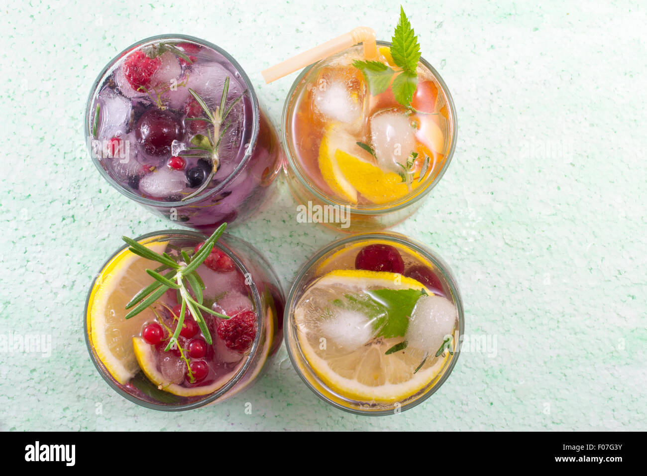 Four non alcoholic fruit cocktails arranged on the green table top view ...