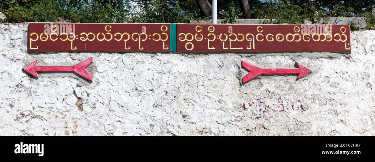 Road signs in Burmese script with arrows pointing to pagodas in either ...