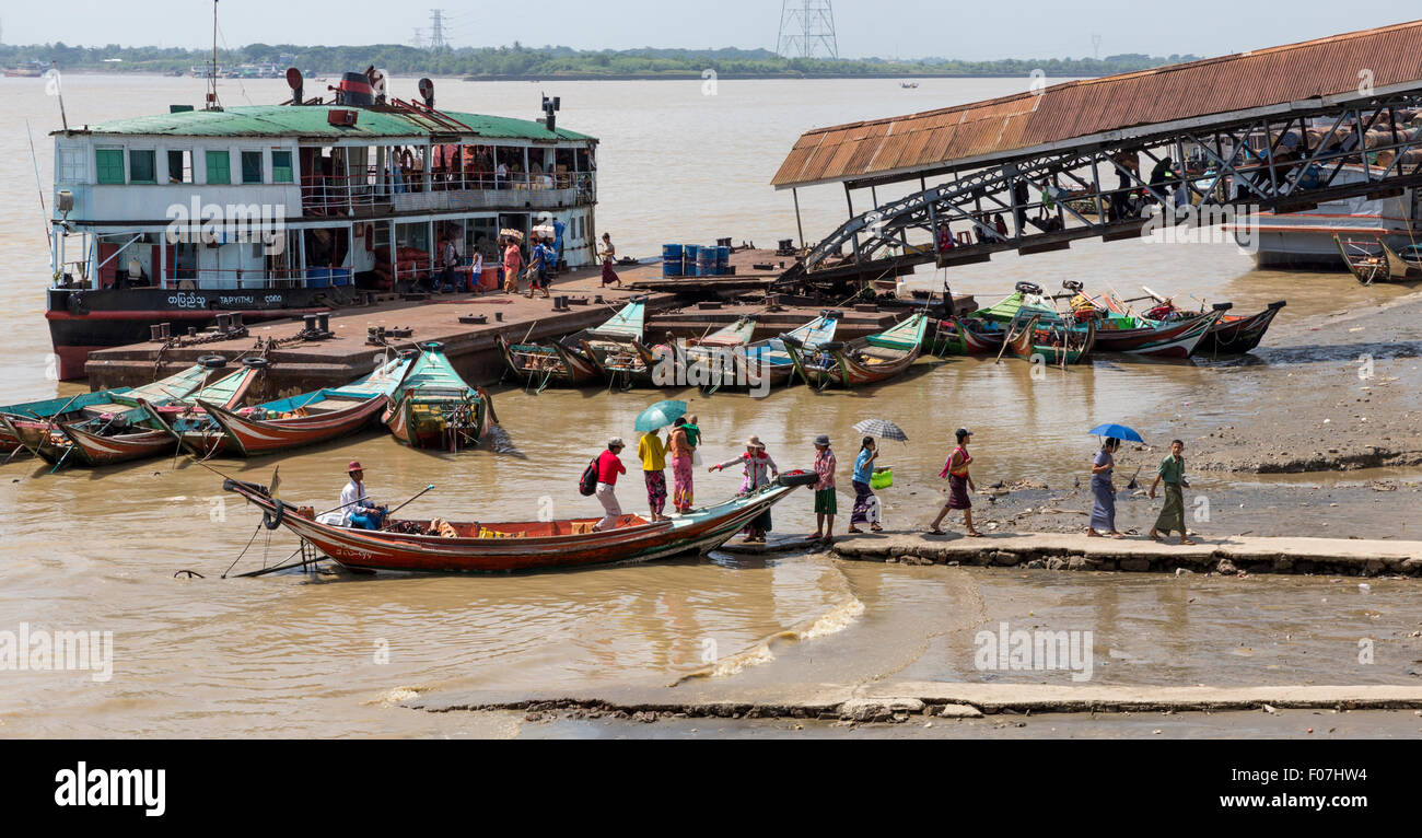 Passengers disembark from ferry at pier on the Yangon River in Yangon ...