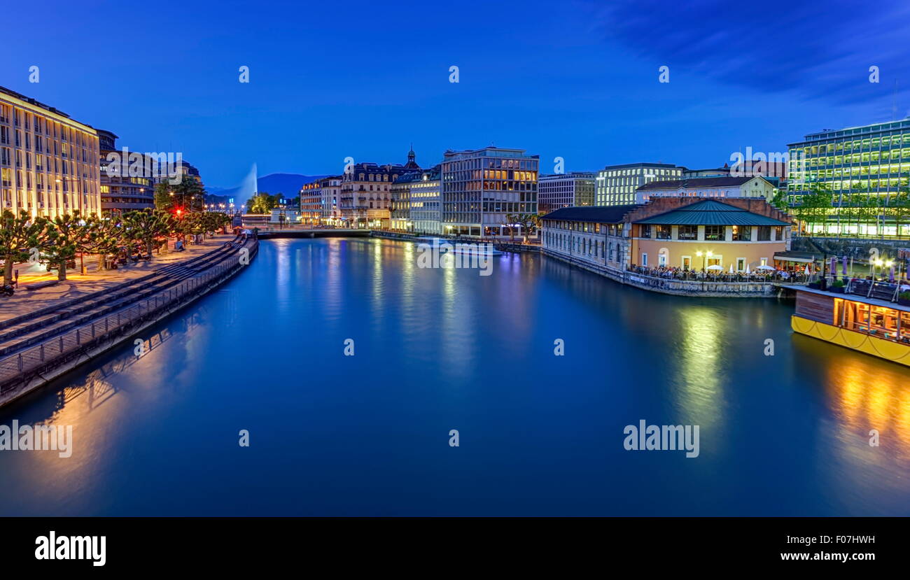 Urban view with famous fountain and Rhone river by night with full moon ...