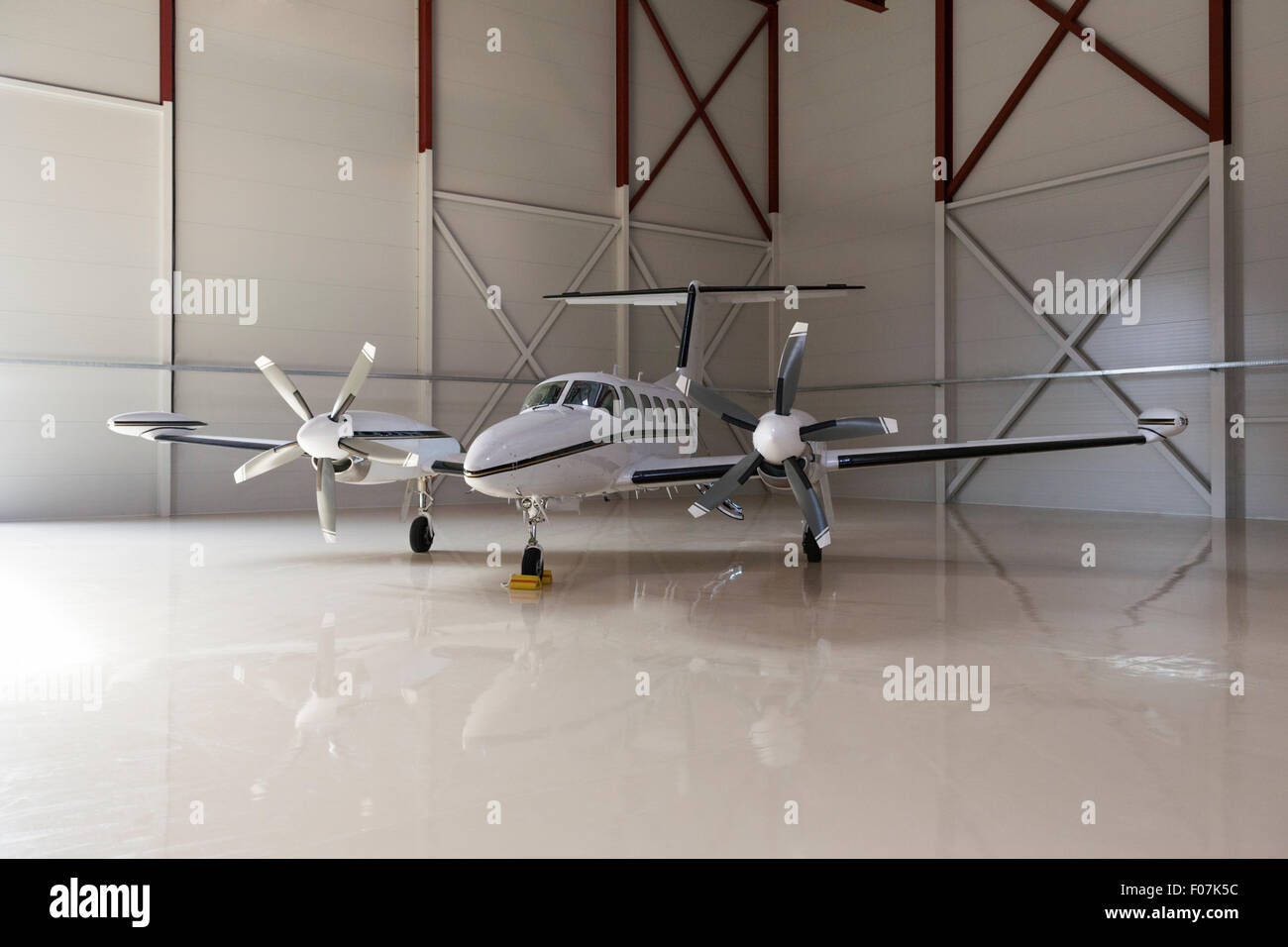 Image of a private plane with two propellers stored in a big hangar ...