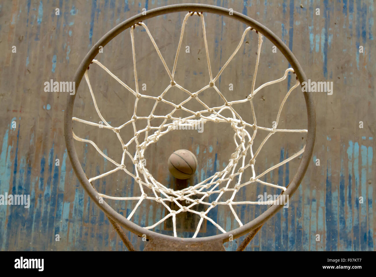 Basketball on wooden floor through a net on metal rim Stock Photo - Alamy