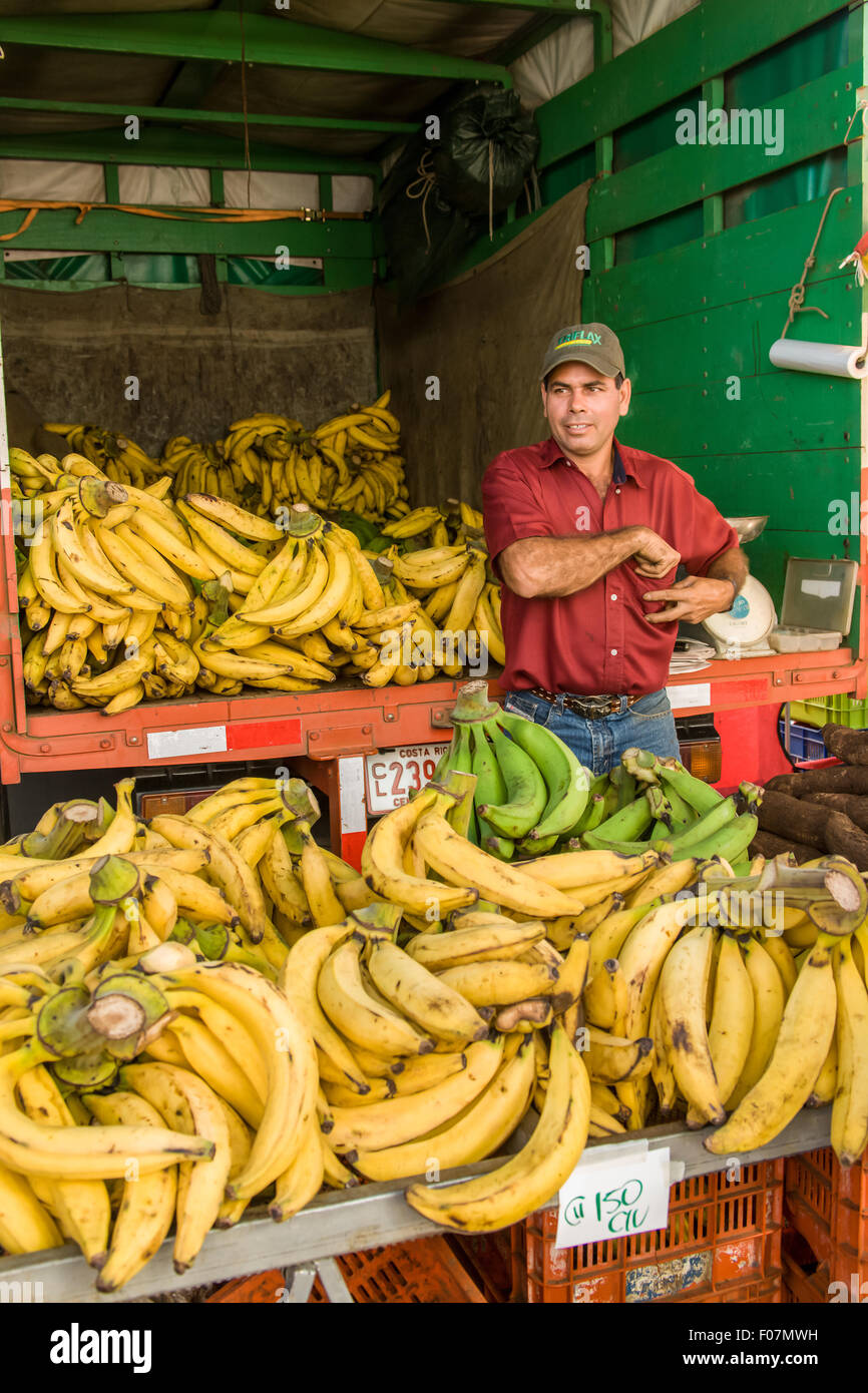 Farmer selling bananas at the La Garita Farmer's Market in Costa Rica ...