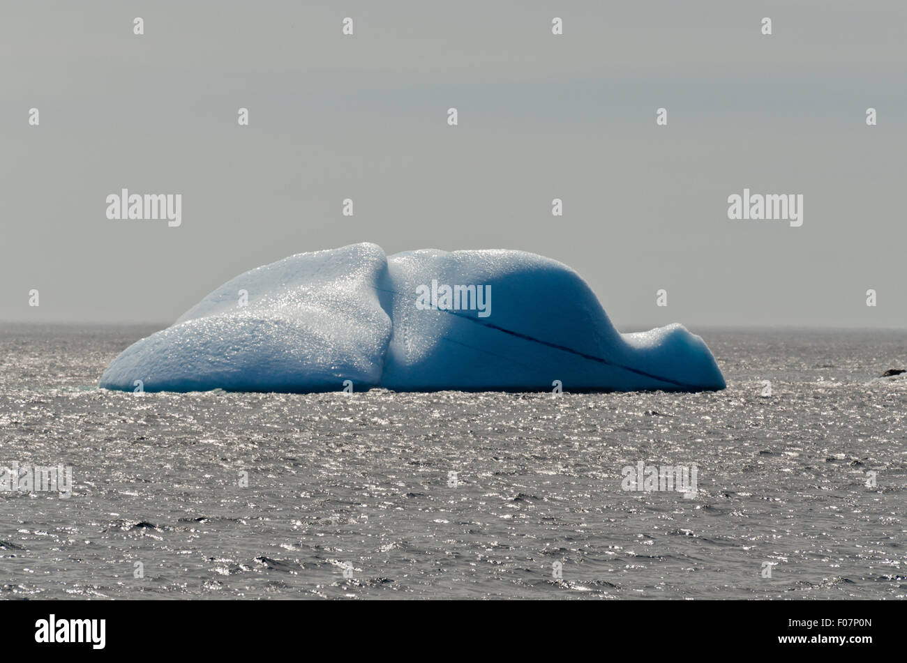 Bright white iceberg on dark water and rock background Stock Photo - Alamy