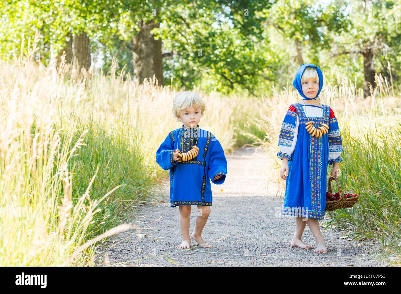 Russian children in traditional Russian costumes playing in the forest ...