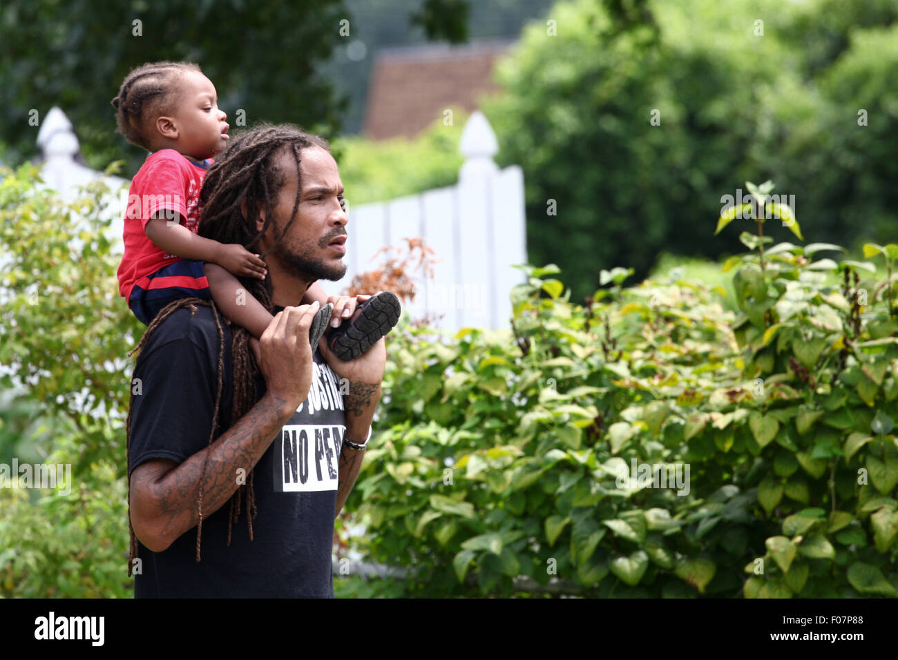 Ferguson, Missouri, USA. 9th Aug, 2015. A father and son stand in their ...