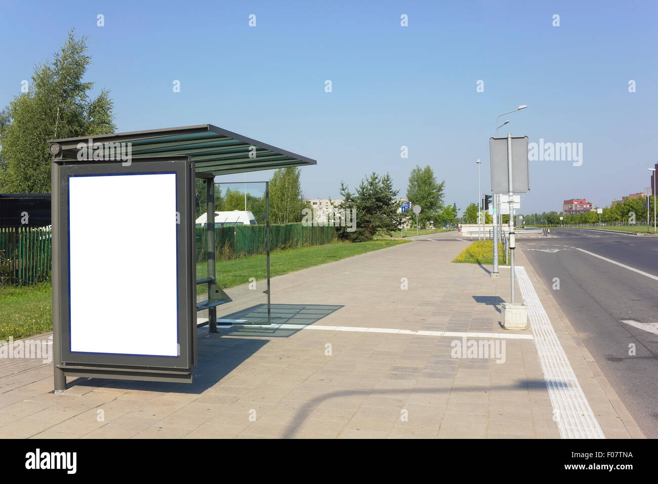 The empty mass production bus-stop near highway in the sleepy summer ...