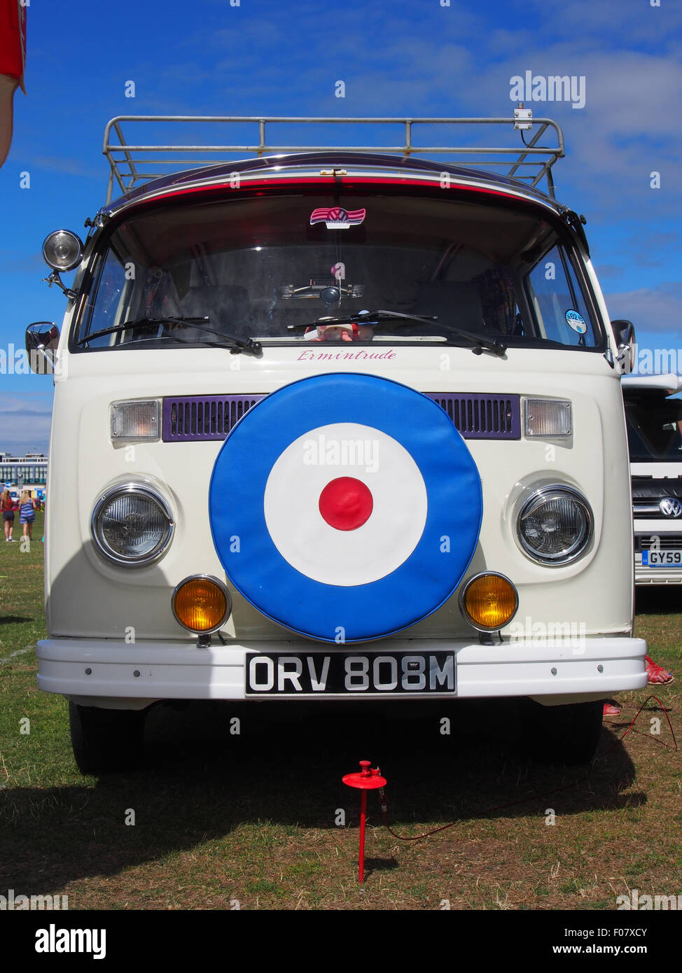 A classic camper van with a spare wheel on the front covered by a ...