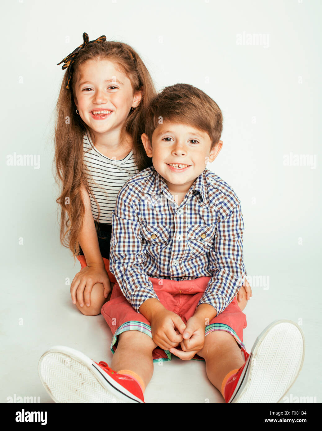 little cute boy and girl hugging playing on white background Stock Photo - Alamy