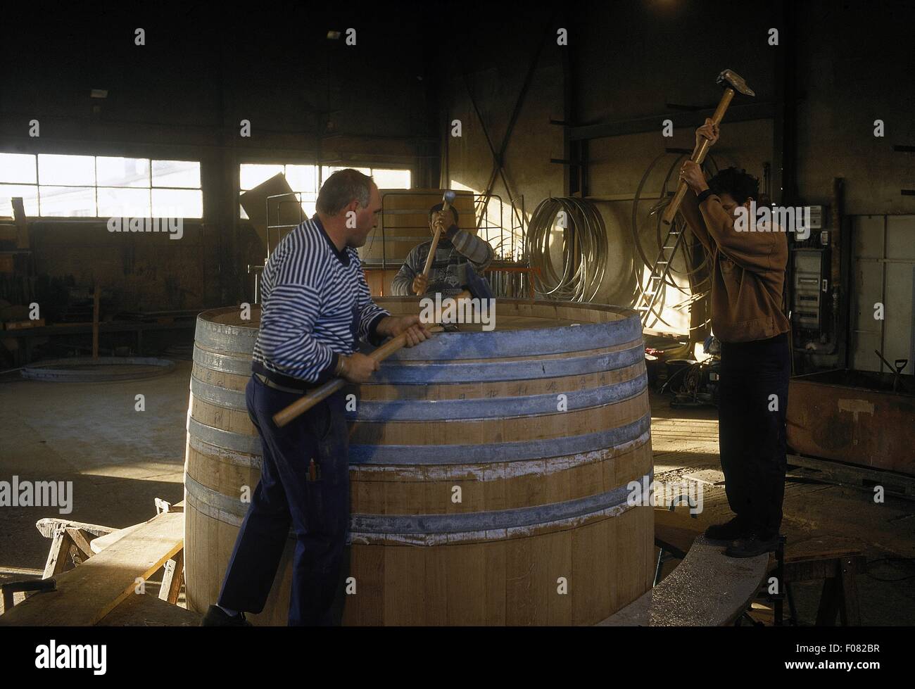 People mounting the hoop during preparation of wine barrels Stock Photo ...