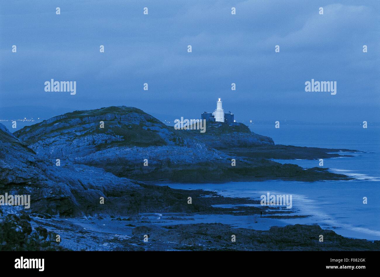 View of Lighthouse, rocky coast at night Stock Photo - Alamy