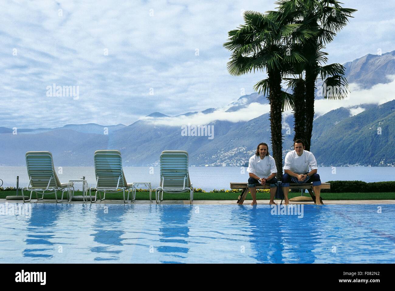 Chefs Chris Trew and Stefan Schulle relaxing at swimming pool Stock ...