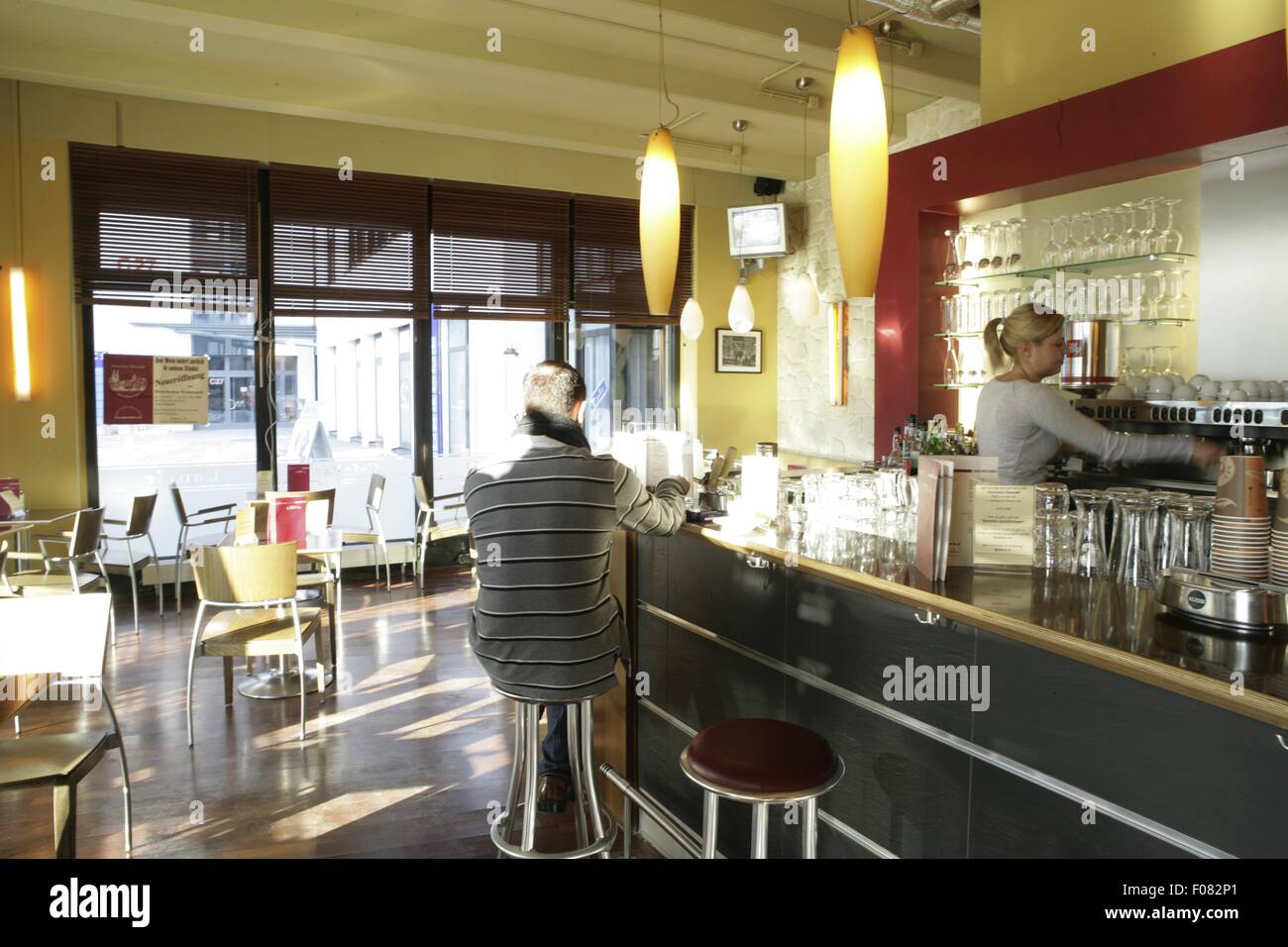 Person sitting at cafe counter, Germany Stock Photo - Alamy