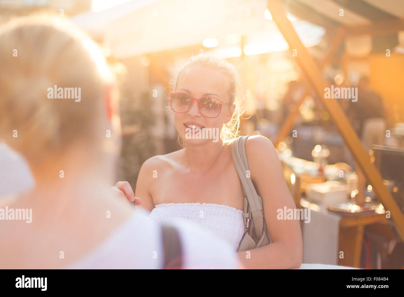 Female friends enjoying a conversation on market Stock Photo - Alamy