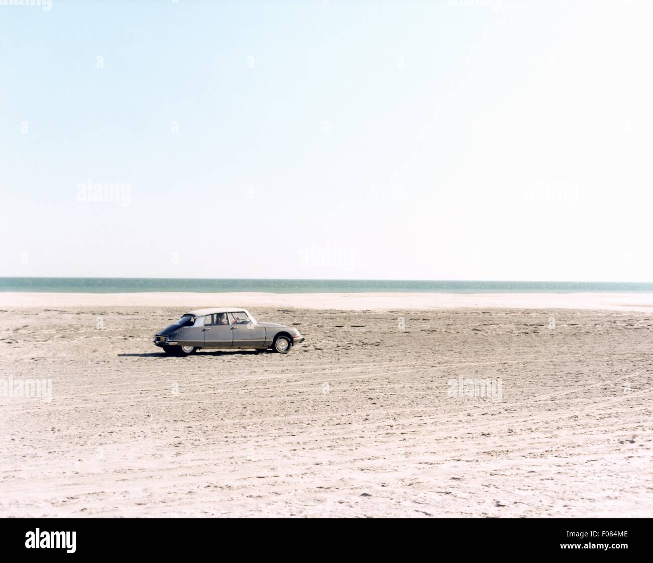 Car with driver at the beach with sea in background Stock Photo - Alamy