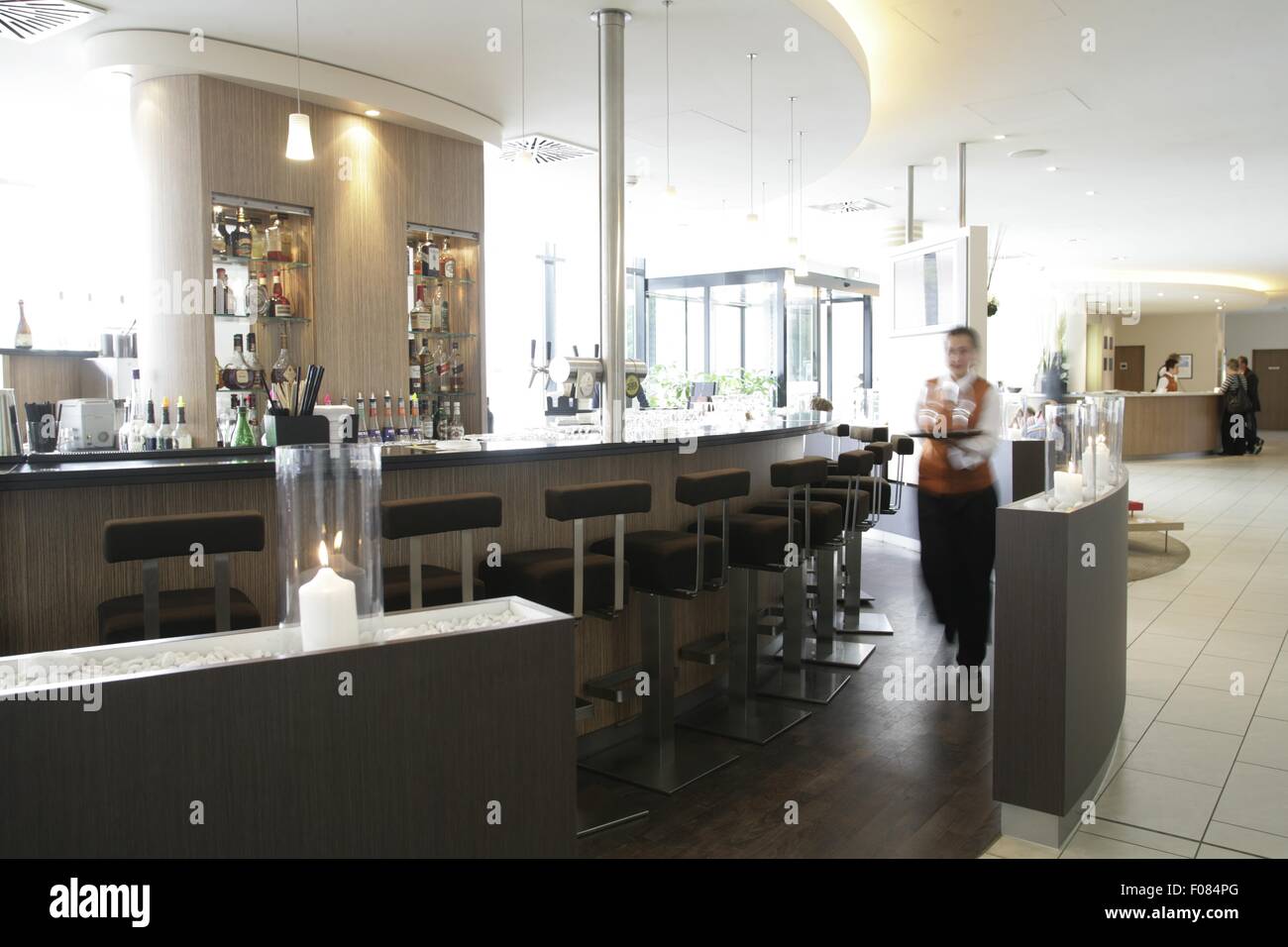 Waiter walking at bar counter in hotel, Germany Stock Photo - Alamy