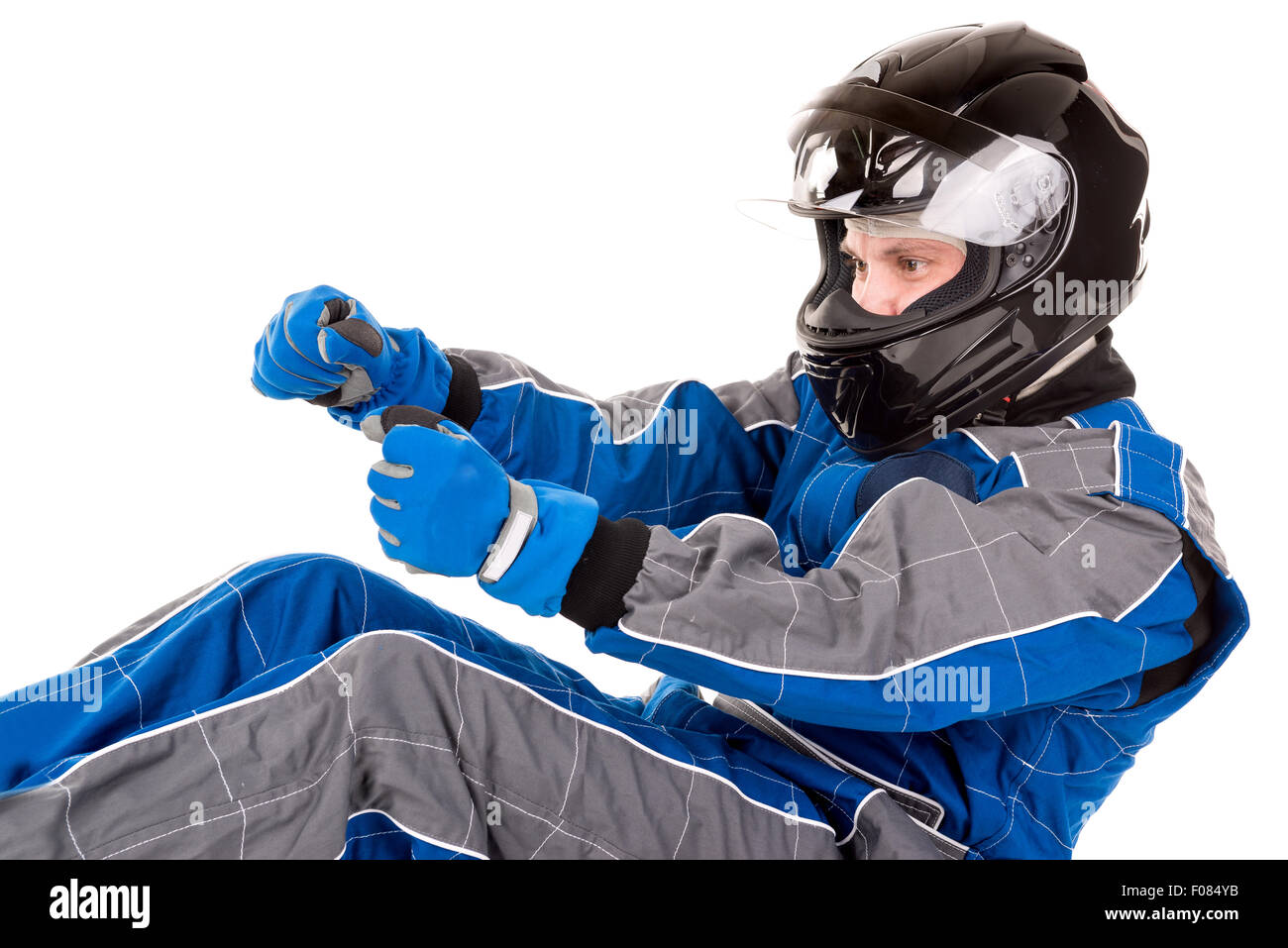 Racing driver posing in driving position in full gear isolated in white ...