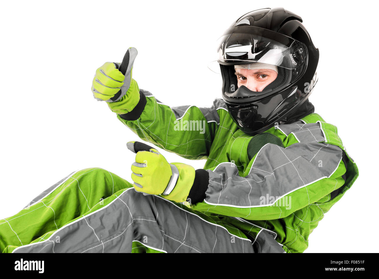 Racing driver posing in driving position in full gear isolated in white ...
