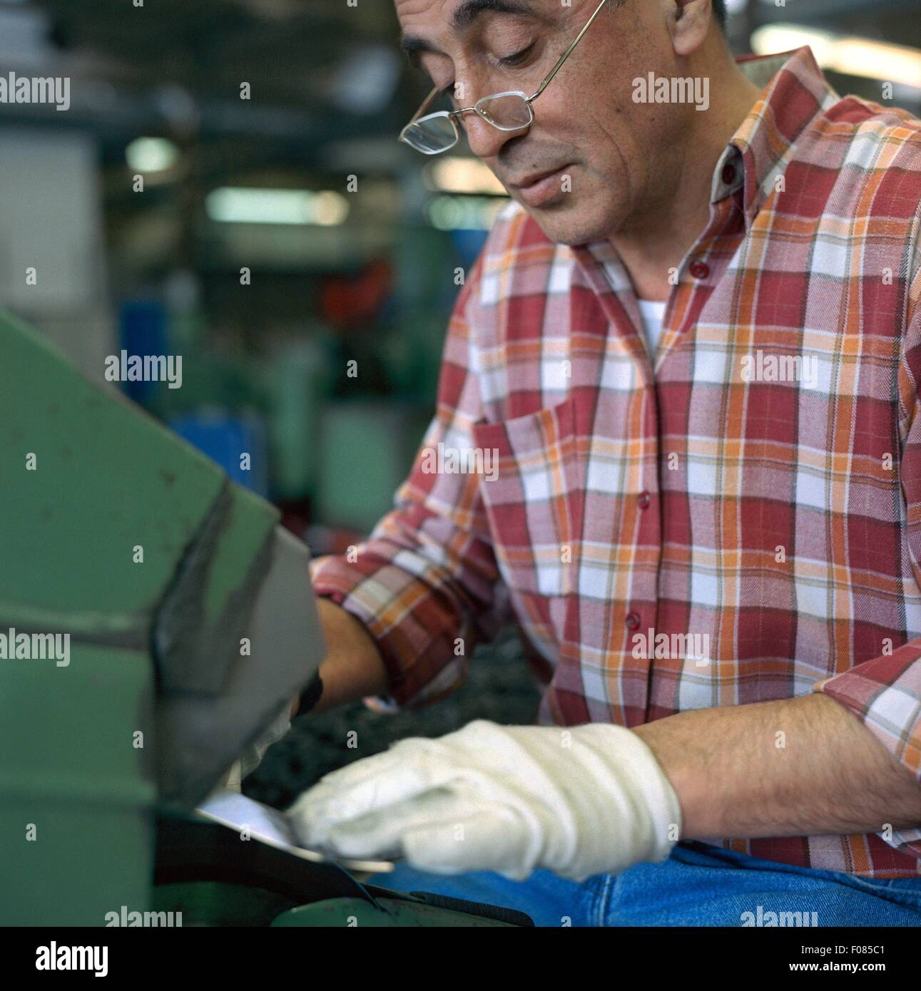 Man carrying out grinding process during blade manufacturing, Swabia ...