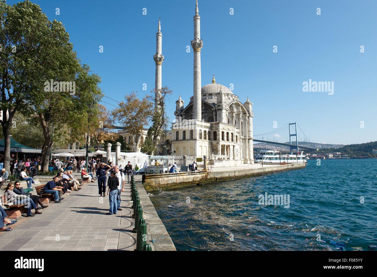 People sitting on benches near Dolmabahce Mosque in Istanbul, Turkey ...