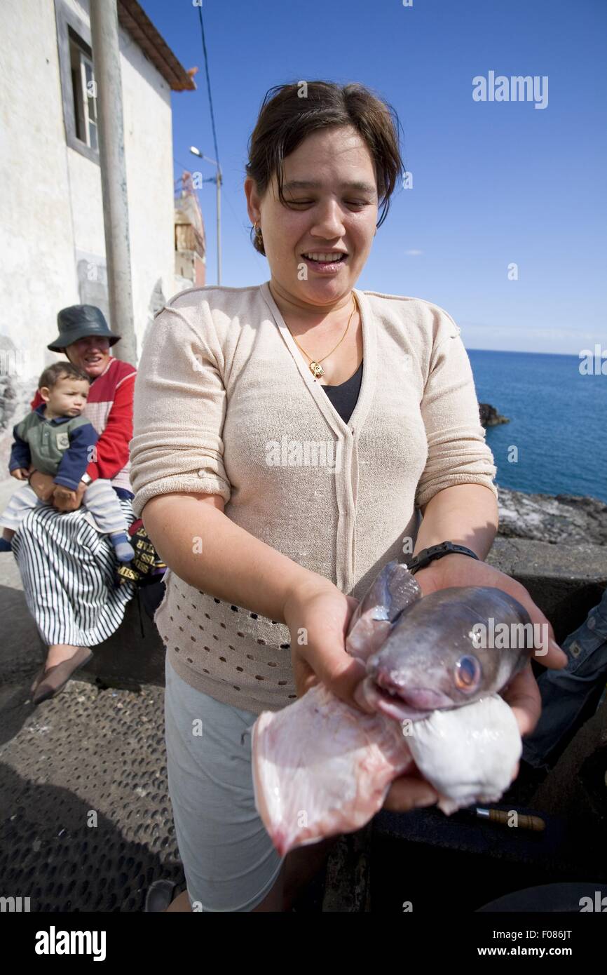 Woman cleaning fish at harbour in Camara de Lobos, Madeira, Portugal ...