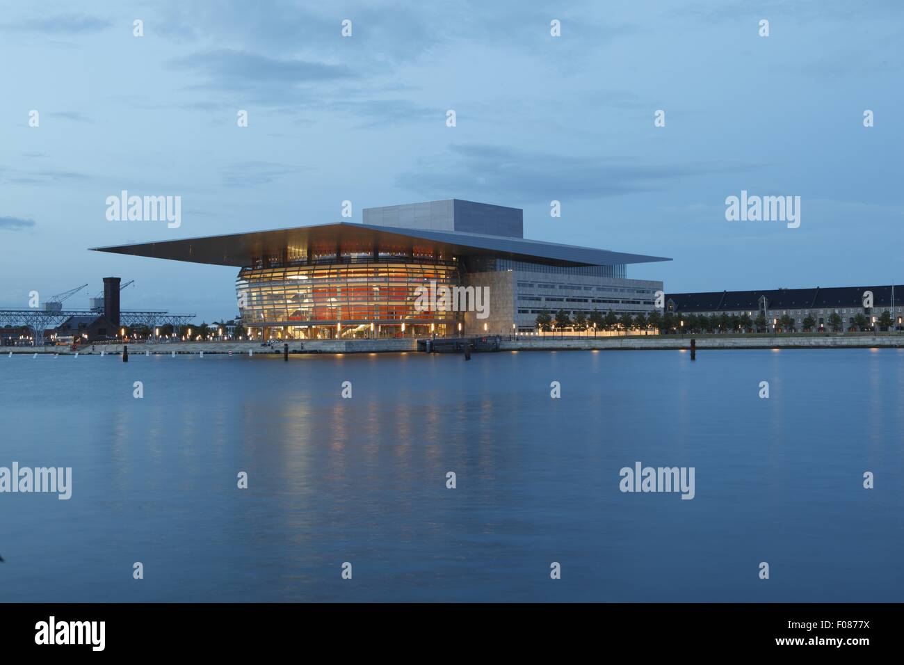Illuminated opera house along river in Copenhagen, Denmark Stock Photo ...