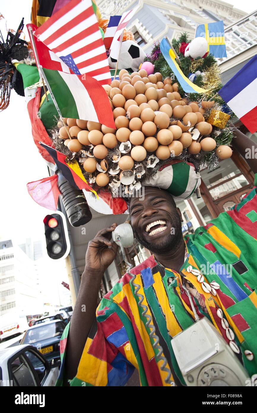 Man carrying eggs on head and laughing while talking over phone, Cape ...