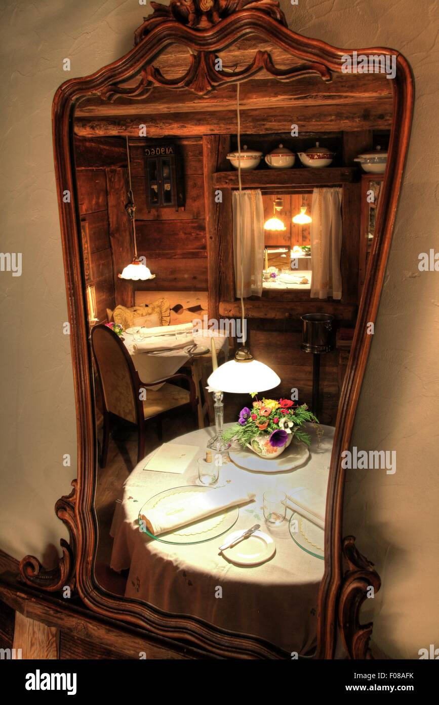 Reflection in mirror of set table at Restaurant La Stua de Michil ...