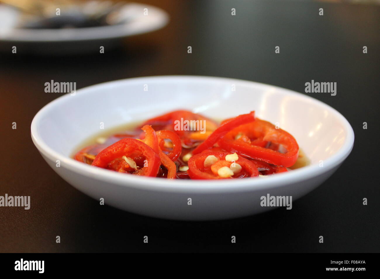 A small saucer of sliced chilli in soy sauce Stock Photo - Alamy