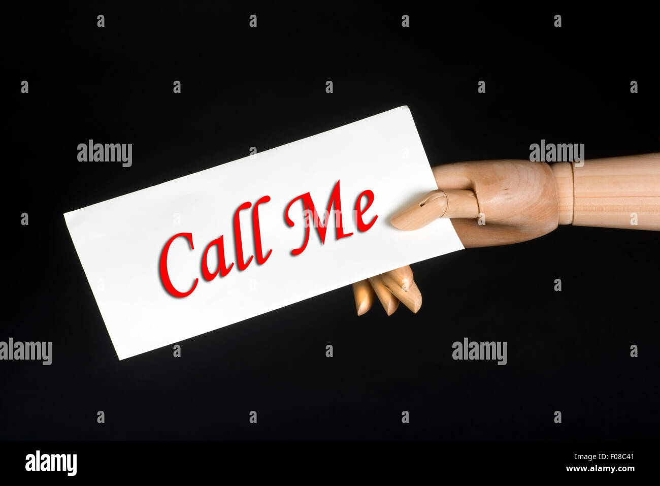 Call me note from strange wooden hand Stock Photo - Alamy