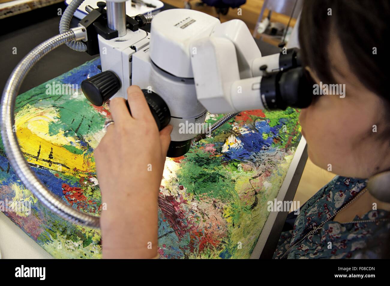 Woman looking at paintings through microscope in The Museum of Modern ...