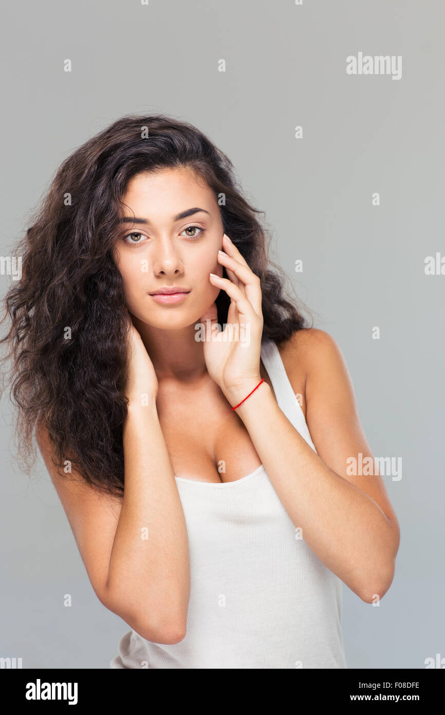 Portrait of a beautiful pretty woman standing over gray background and ...