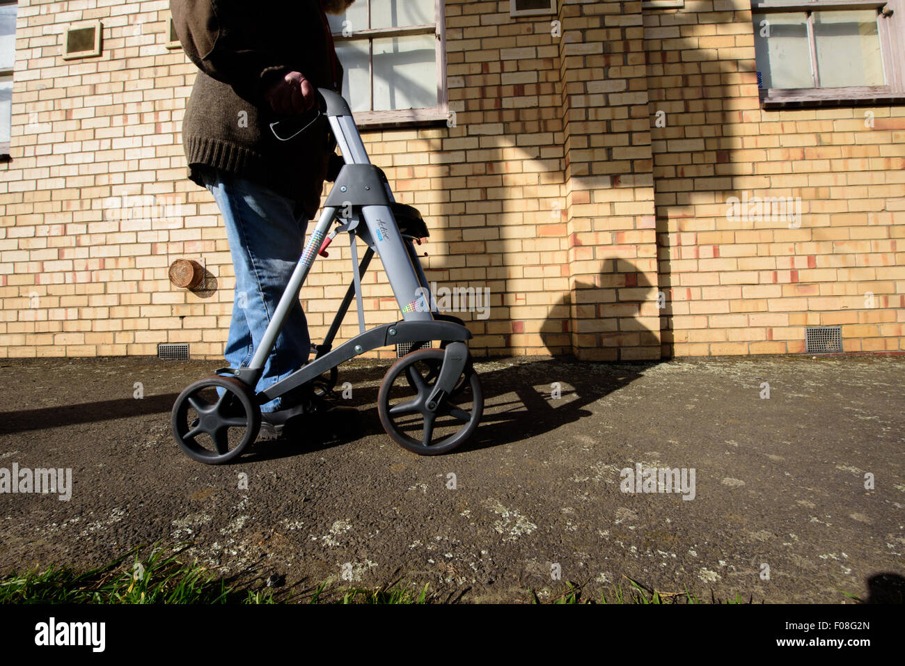 Elderly man with walking frame on sunny day Stock Photo - Alamy