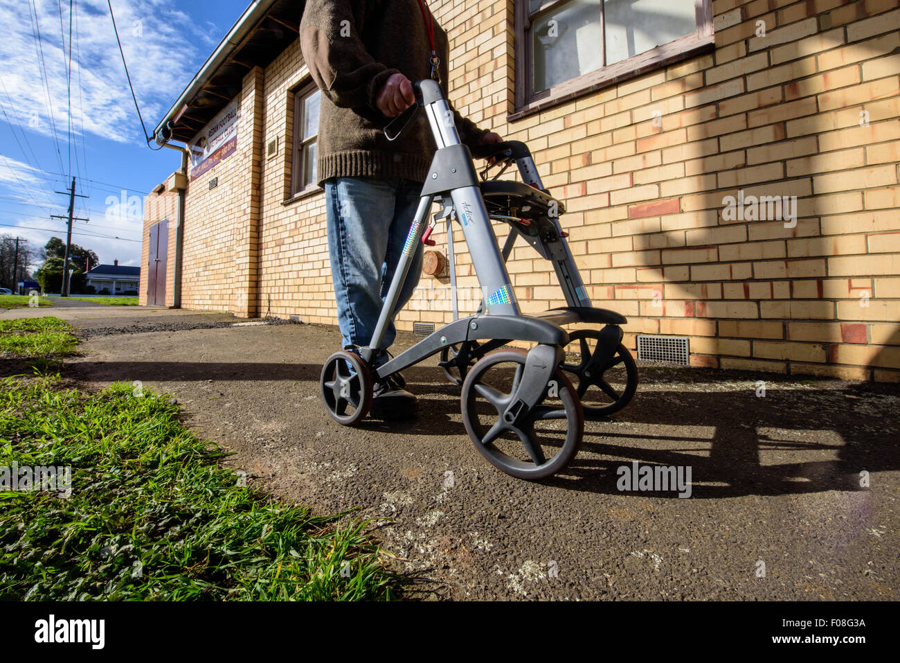Elderly man with walking frame on sunny day Stock Photo - Alamy