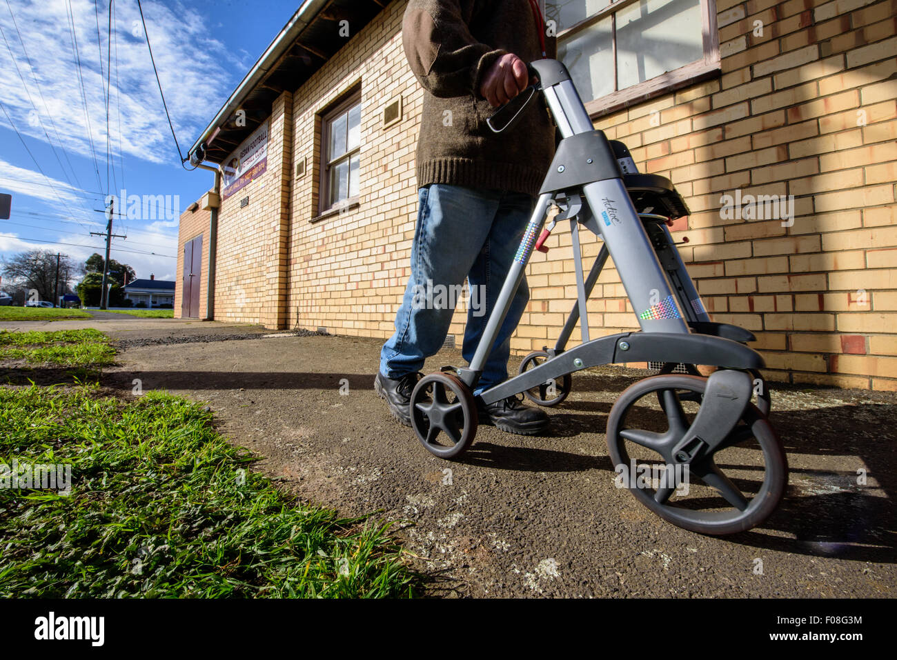 Elderly man with walking frame on sunny day Stock Photo - Alamy