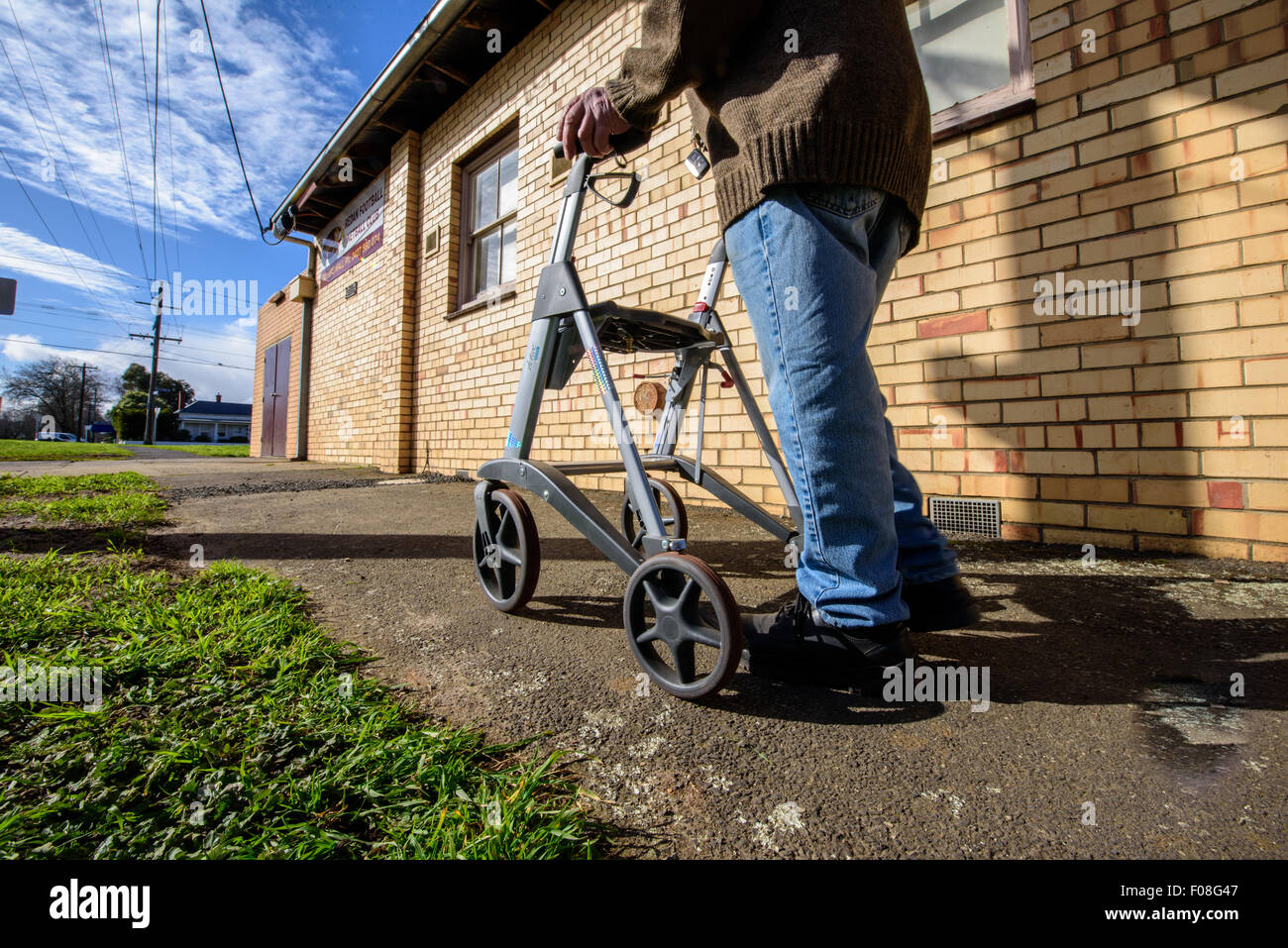 Elderly man with walking frame on sunny day Stock Photo - Alamy