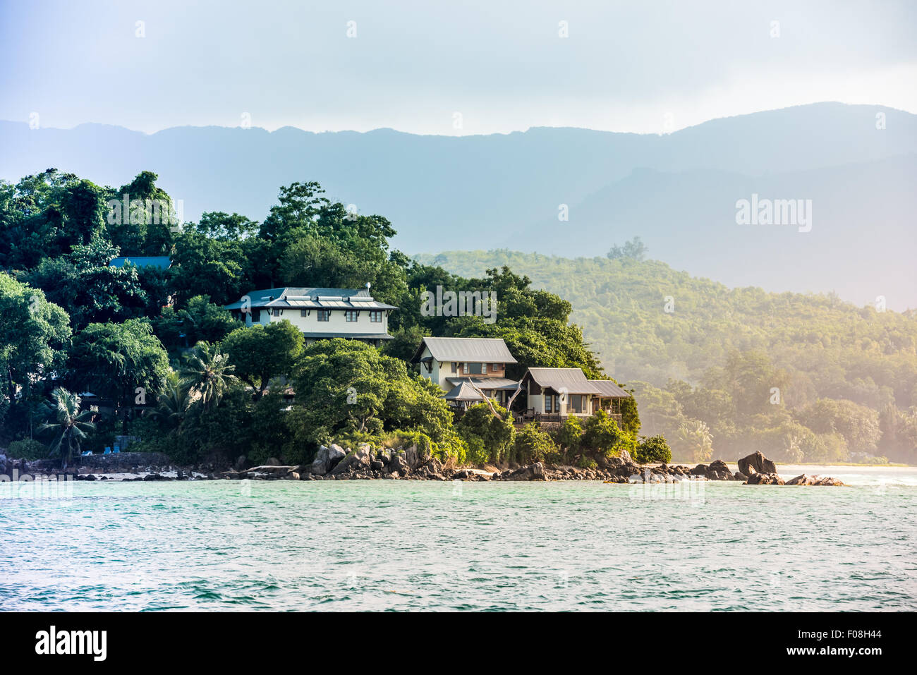 View of Seychelles coastline with houses in the forest. Horizontal shot ...