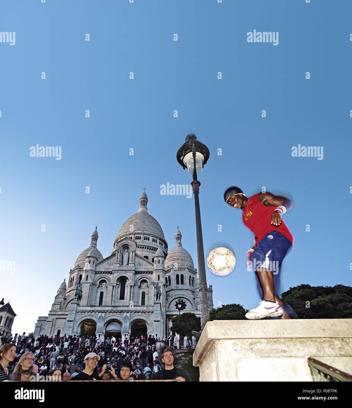 People watching man doing ball acrobat in front of Sacre-Coeur, Paris ...