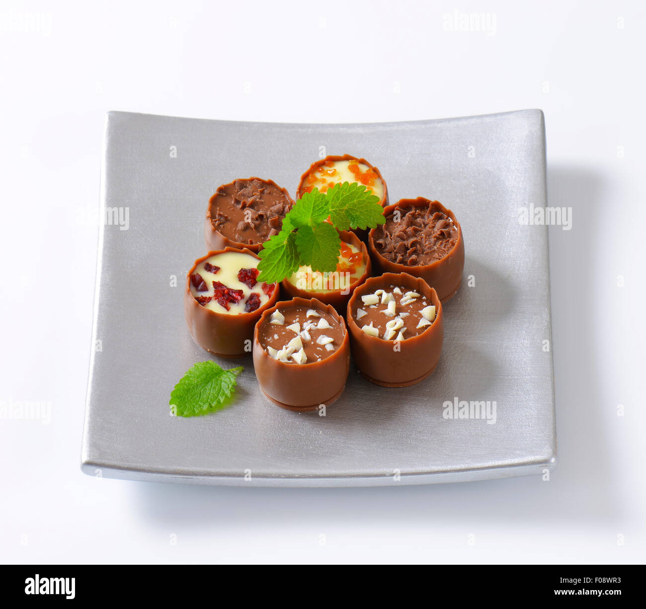 Delicate milk chocolate cups with liqueur and ganache centres Stock ...