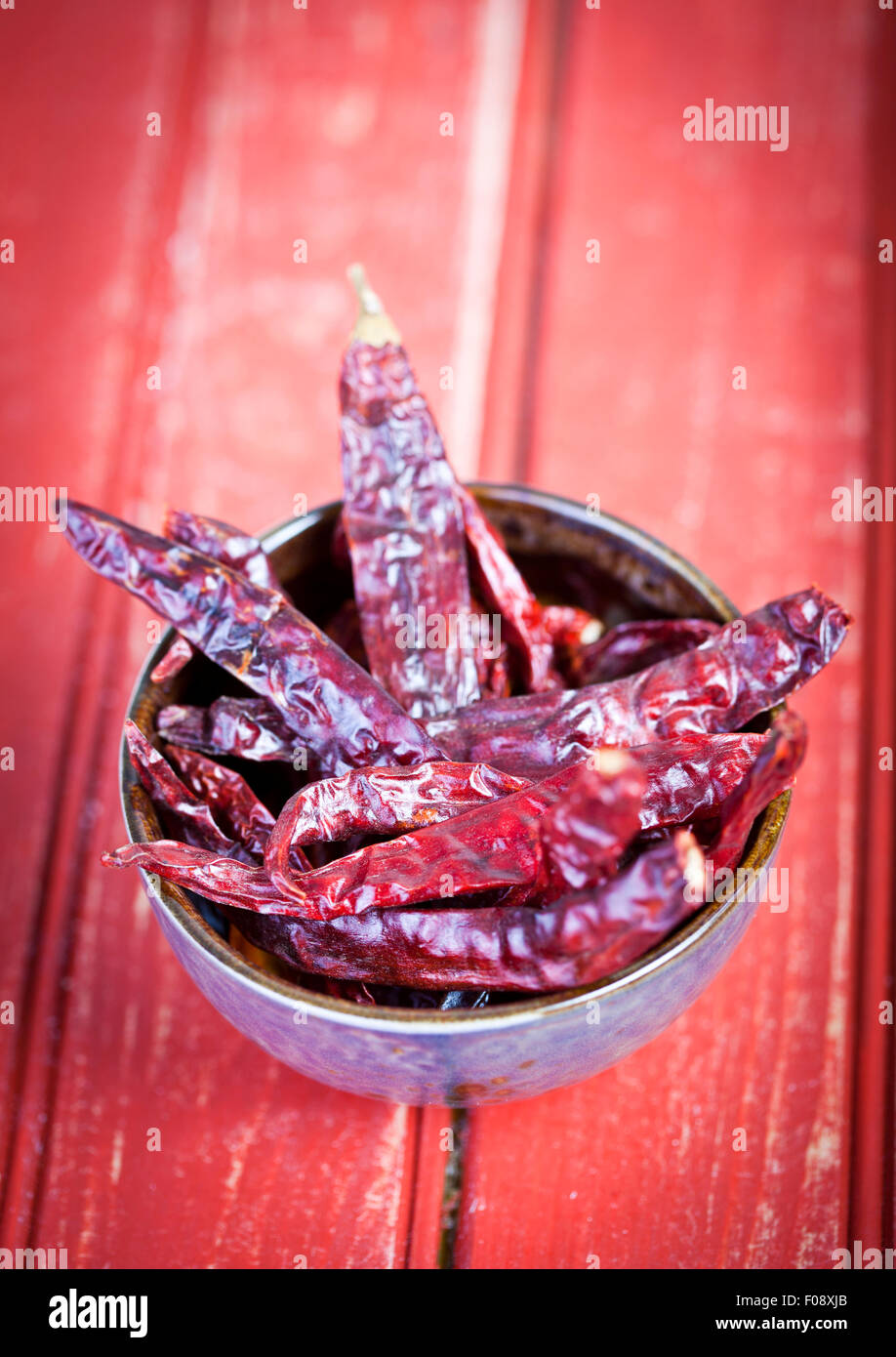 Dried red pepper on a red table tp background Stock Photo - Alamy