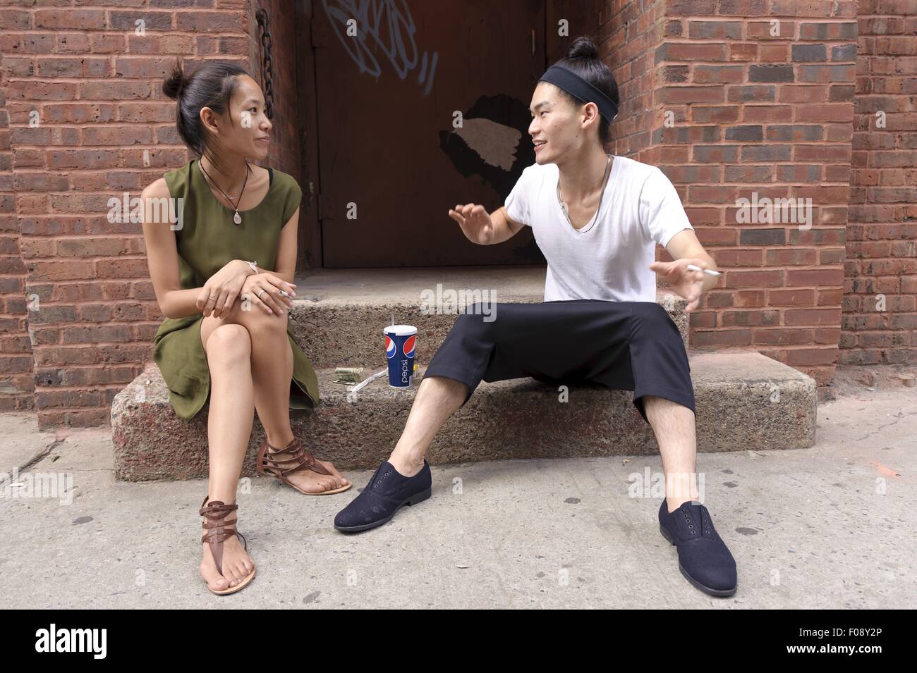 Man and woman talking while sitting on steps, New York Stock Photo - Alamy