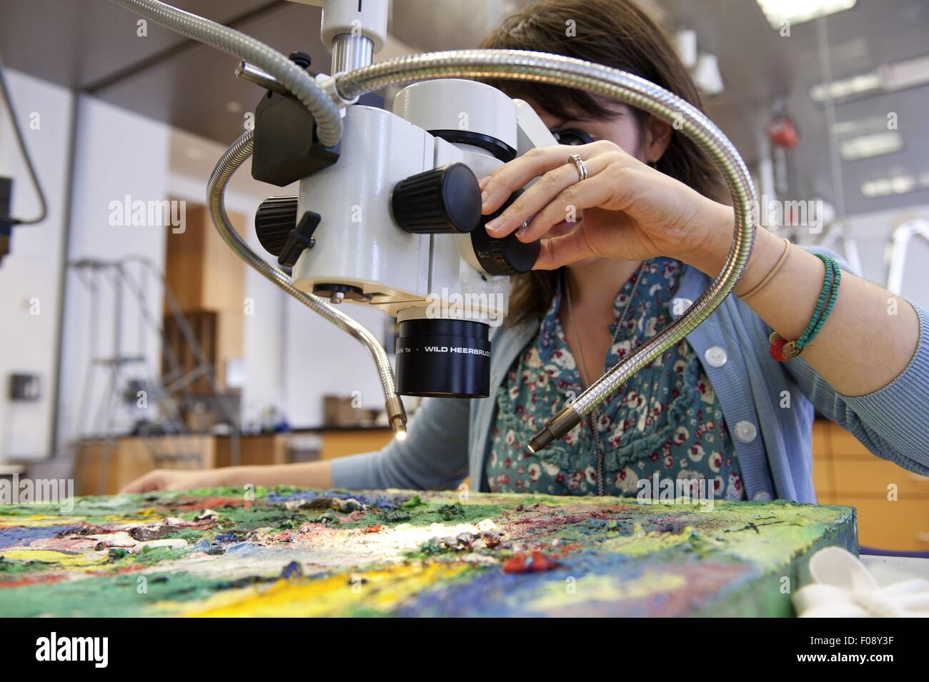 Woman looking at paintings through microscope in The Museum of Modern ...